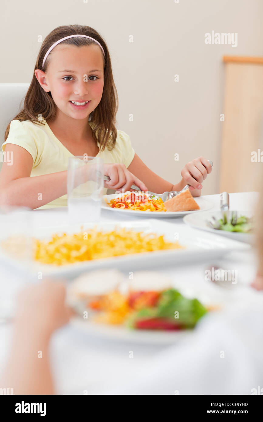 Happy girl having dinner at dinner table Stock Photo - Alamy