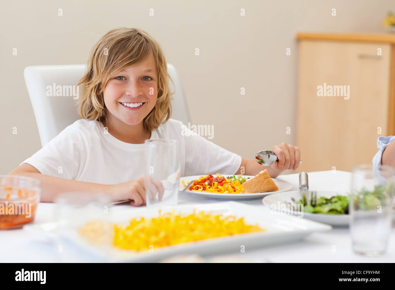 Smiling boy at the dinner table Stock Photo - Alamy
