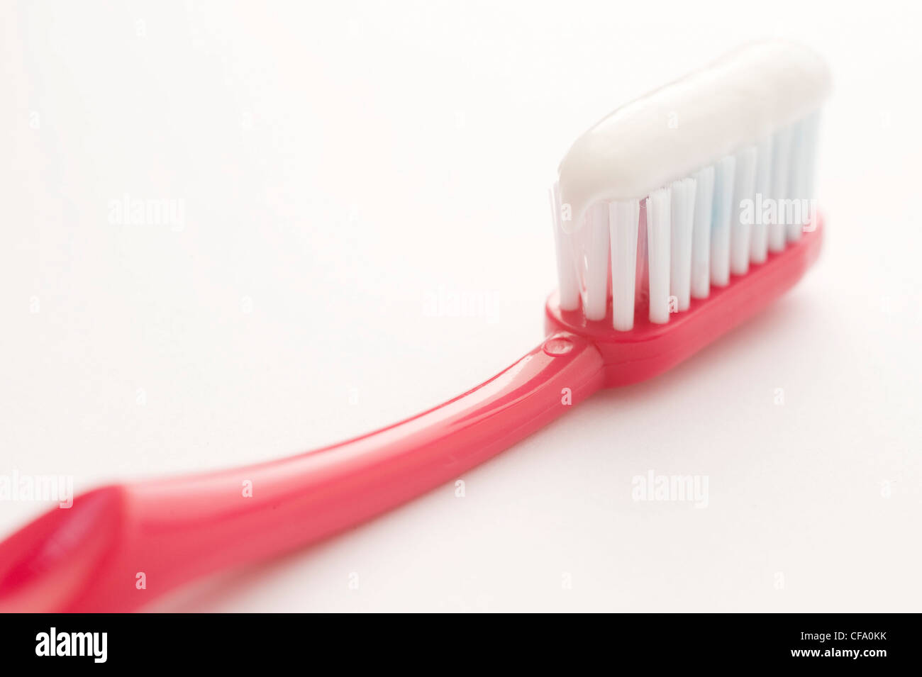 White toothpaste on a red toothbrush Stock Photo - Alamy