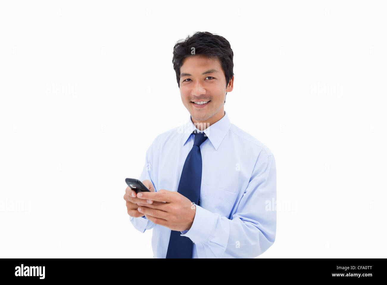 Smiling businessman sending a text message Stock Photo - Alamy