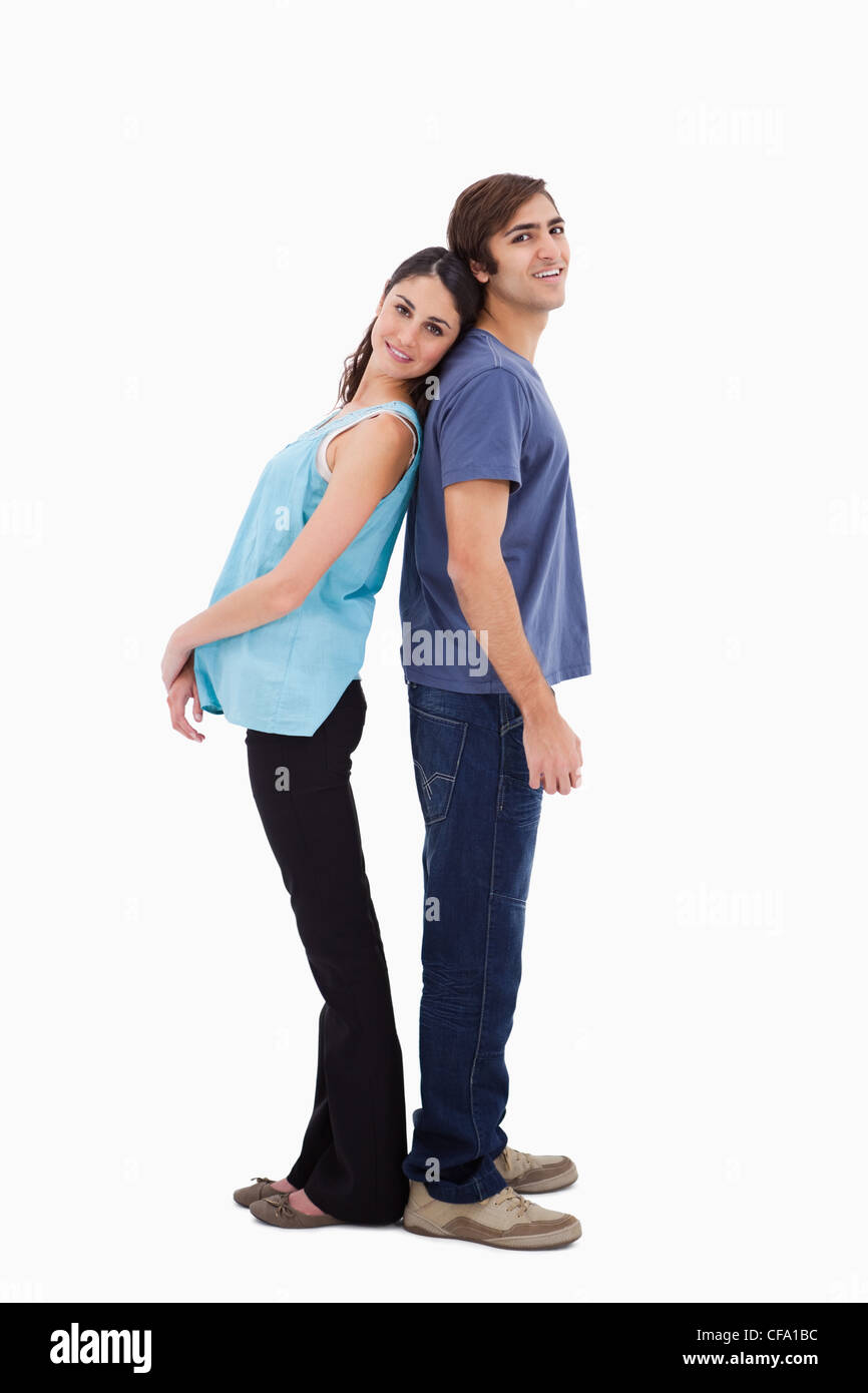 Portrait of a young couple standing back to back Stock Photo - Alamy
