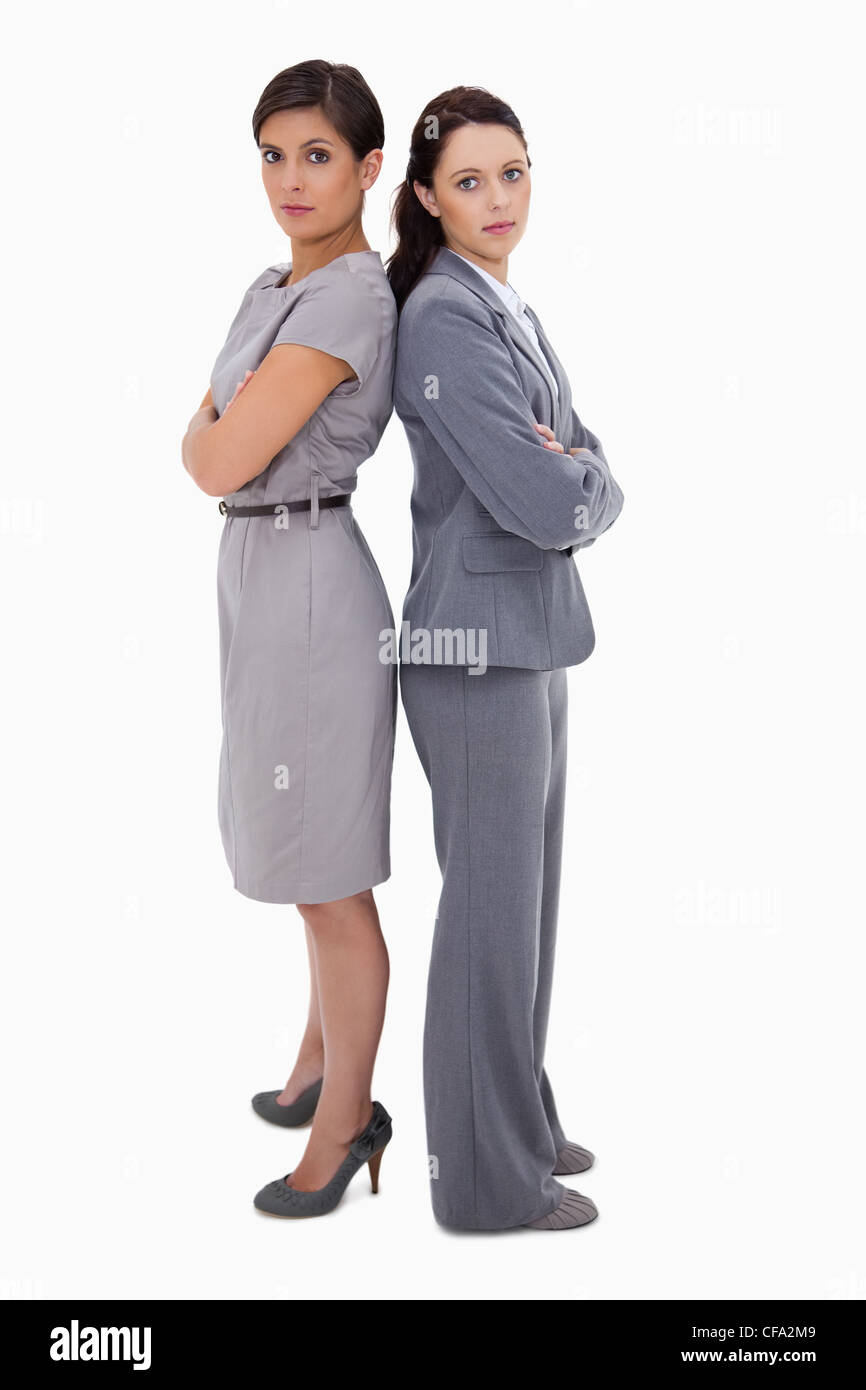 Serious businesswomen standing back on back Stock Photo - Alamy