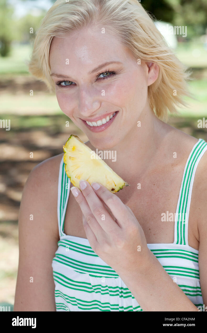 Female eating pineapple Stock Photo - Alamy