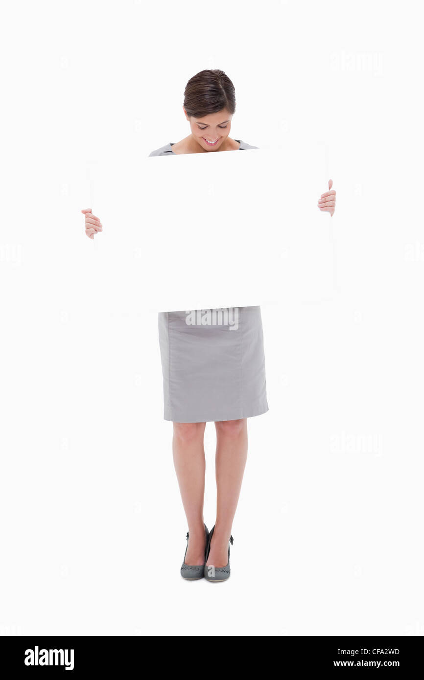 Woman looking down at blank sign in her hands Stock Photo - Alamy