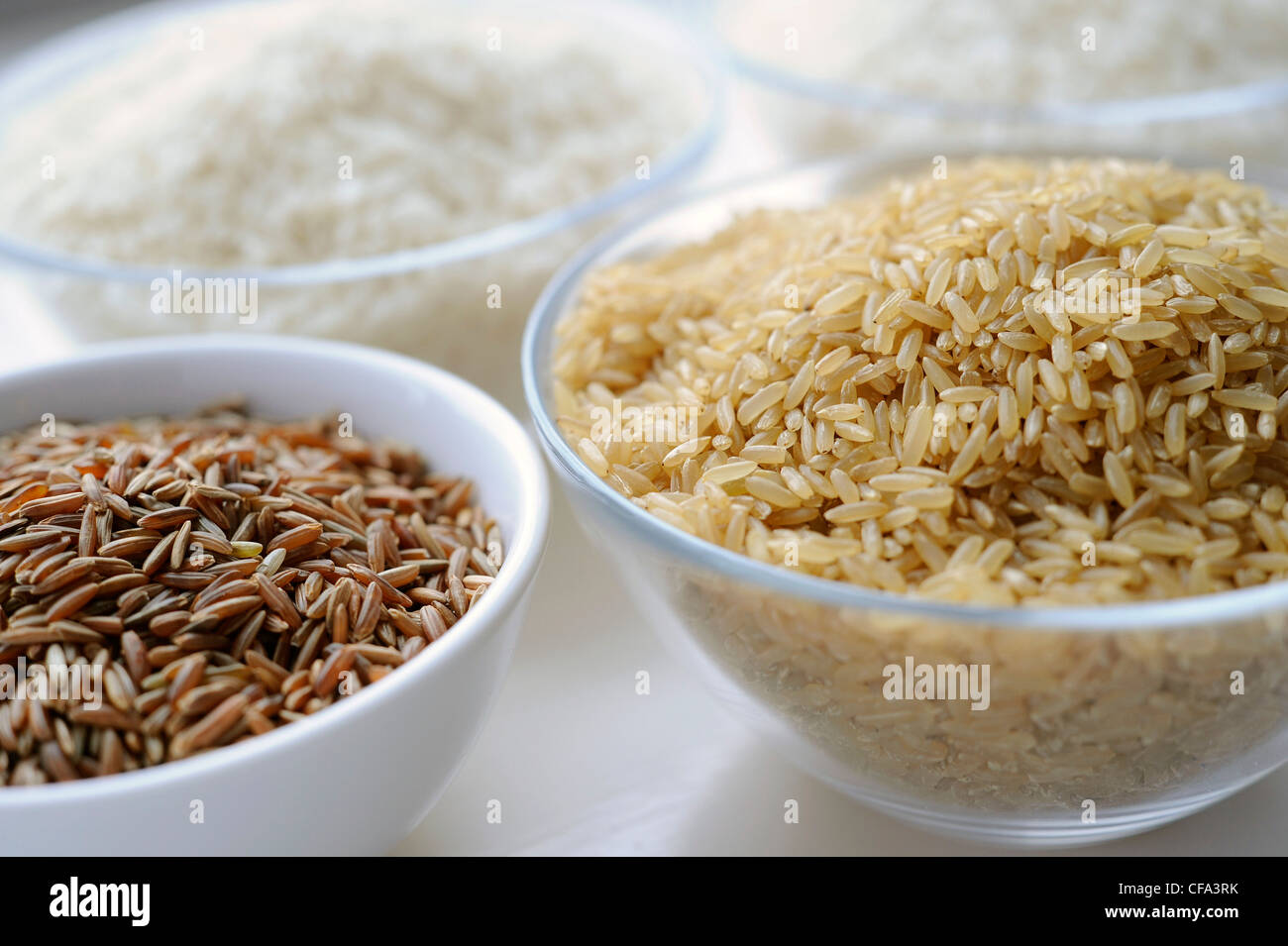 Four bowls of different varieties of rice, with a bowl of red rice and ...