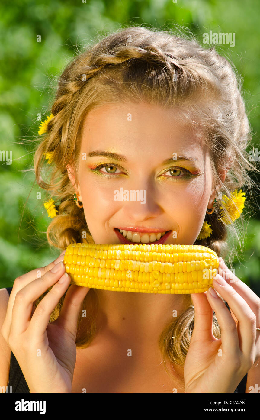 Close-up outdoor portrait of young beauty woman eating corn-cob Stock ...