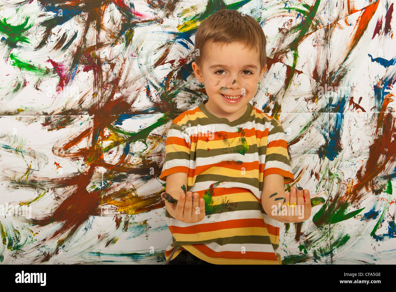 Messy child boy having fun against painted background Stock Photo - Alamy