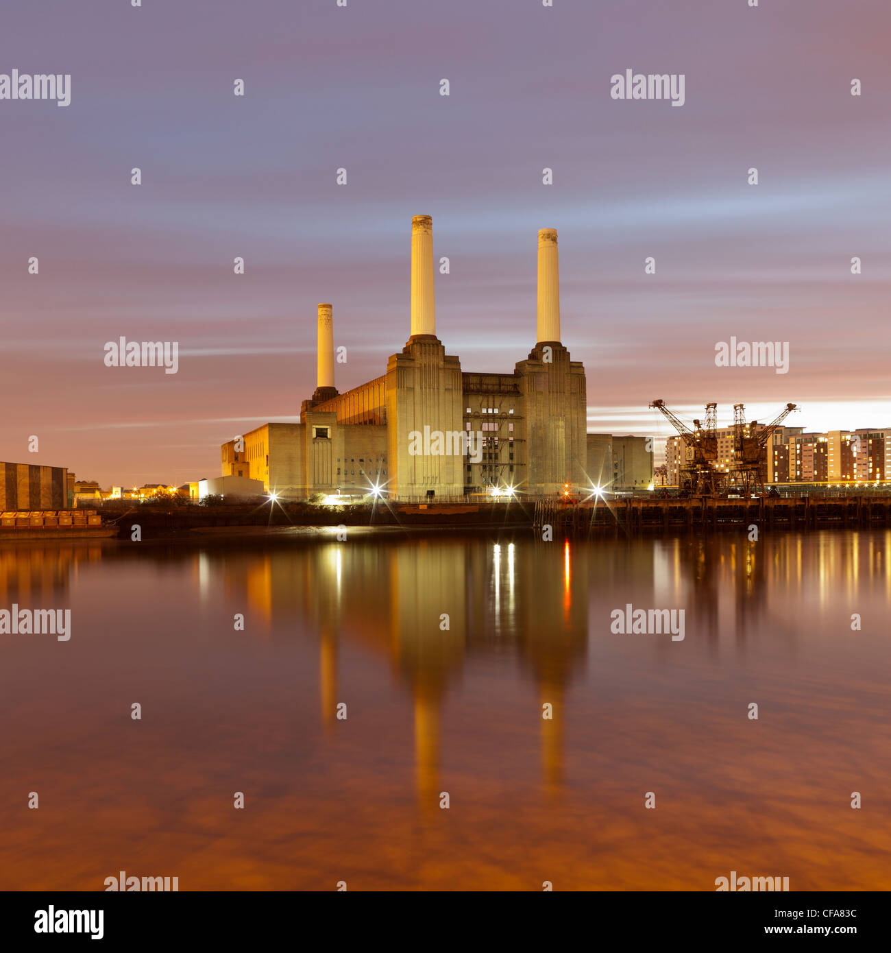 Factory on waterfront lit up at night Stock Photo - Alamy