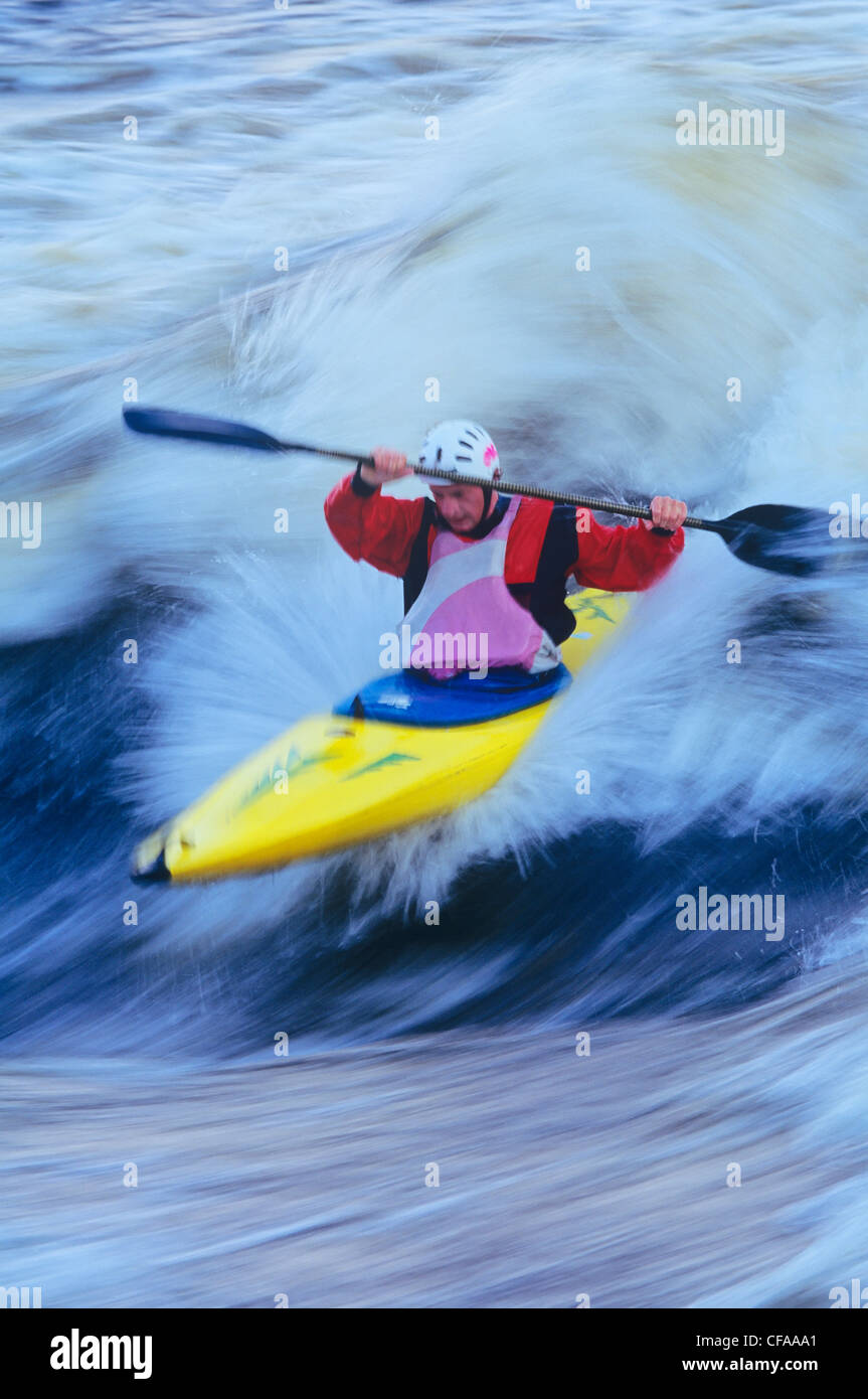 Young man kayaking a standing wave on the ottawa river, Ontario, Canada ...
