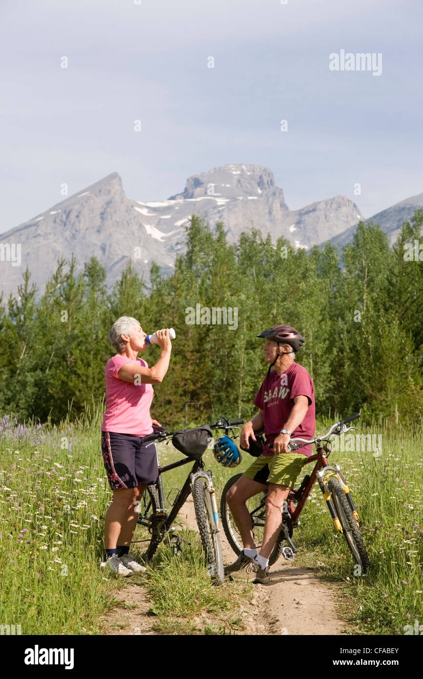 Active, fit, elderly couple mountain biking on trail in Fernie, British ...