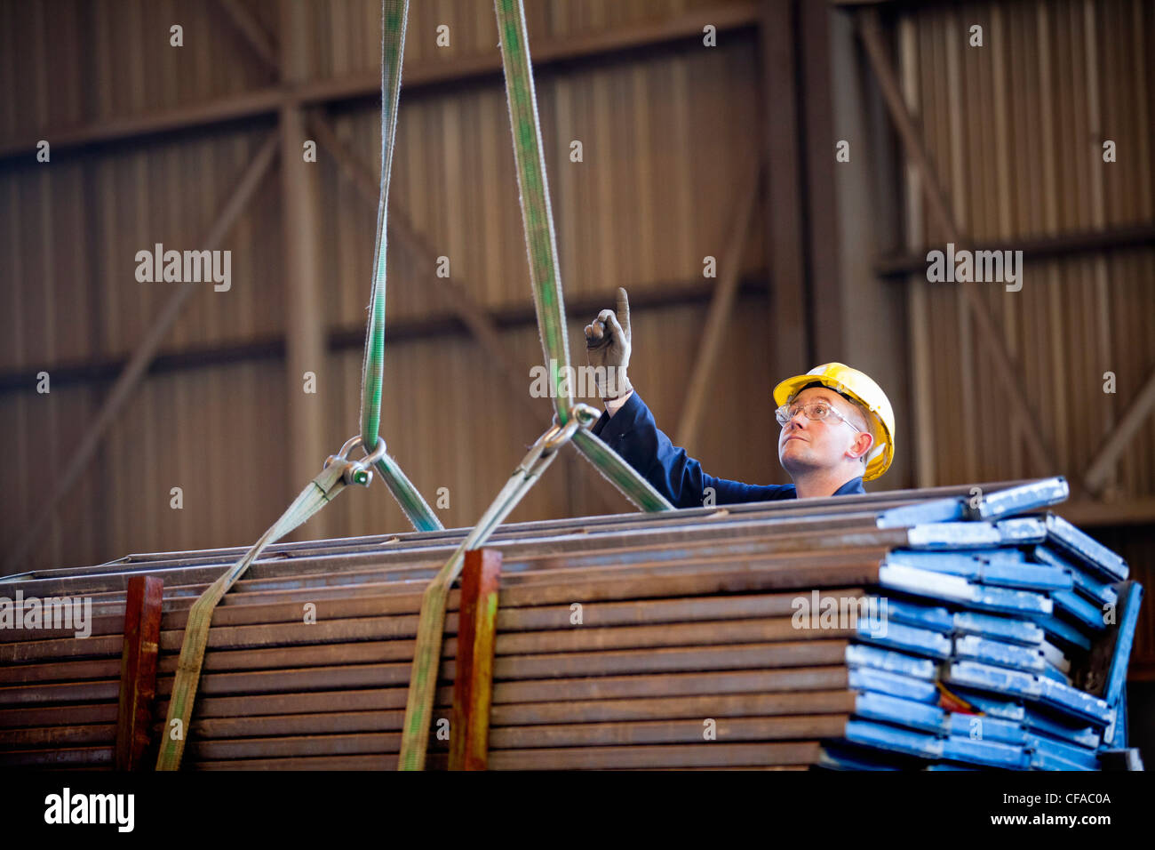 Worker signaling crane at shipyard Stock Photo - Alamy