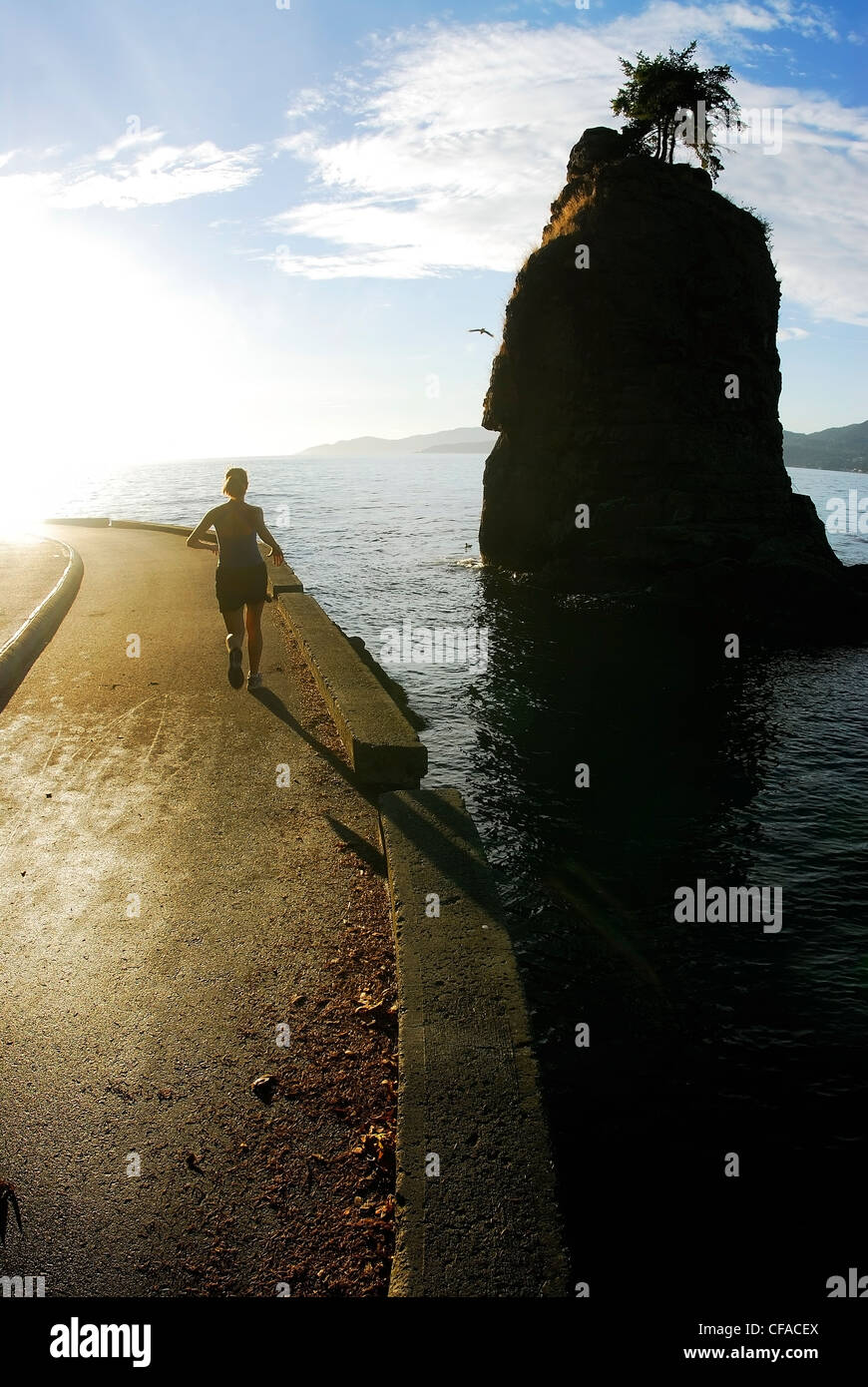 Woman enjoys a sunny day running on the Stanley Park Seawall, Near ...
