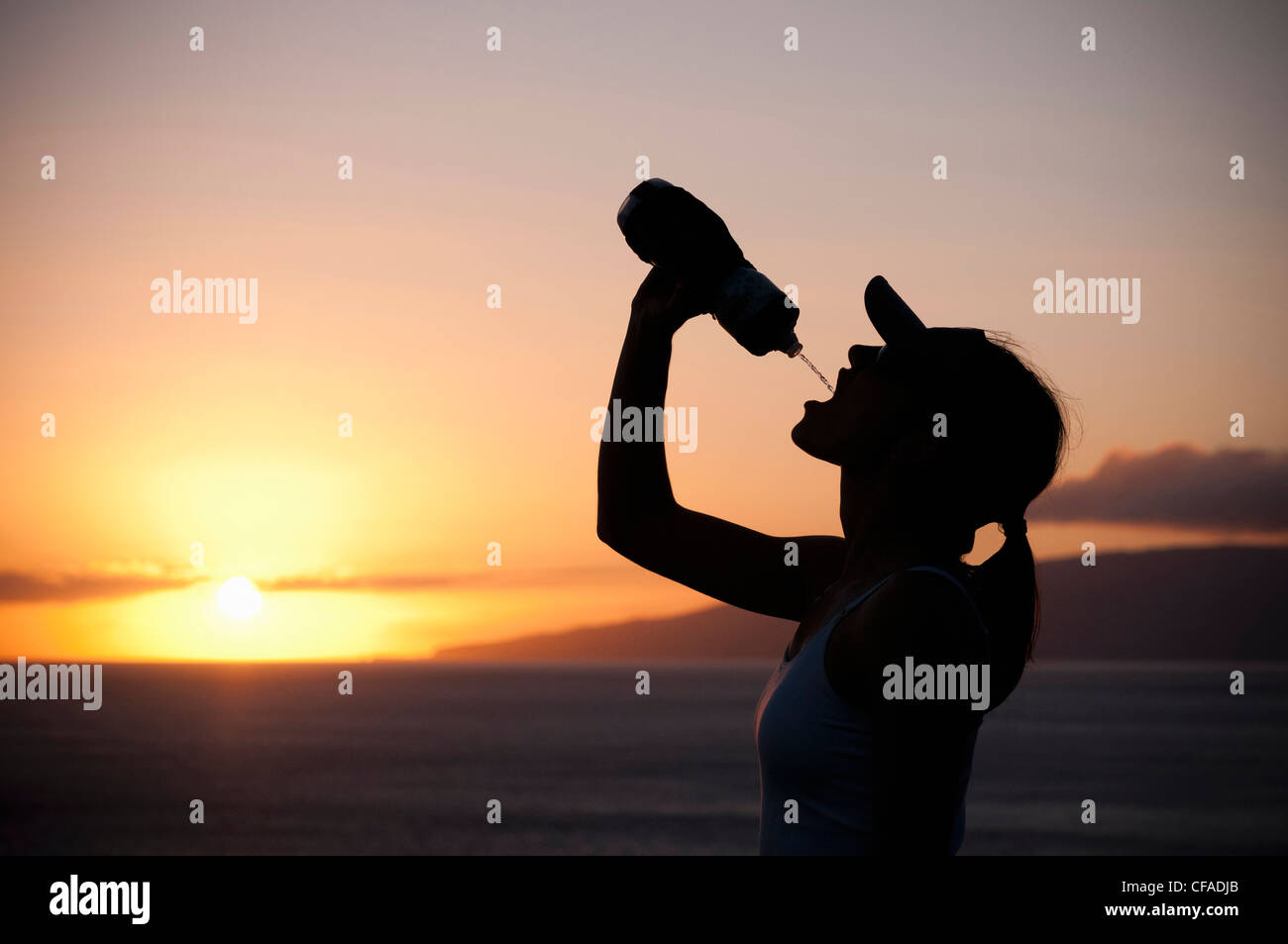 Runner drinking water on beach Stock Photo - Alamy