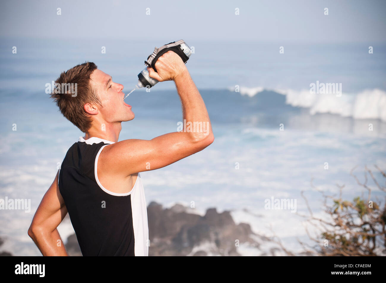 Runner drinking water on beach Stock Photo - Alamy