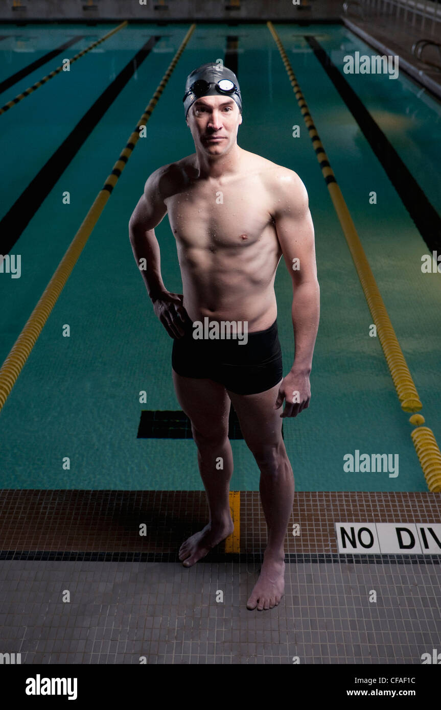 Swimmer standing by swimming pool Stock Photo - Alamy