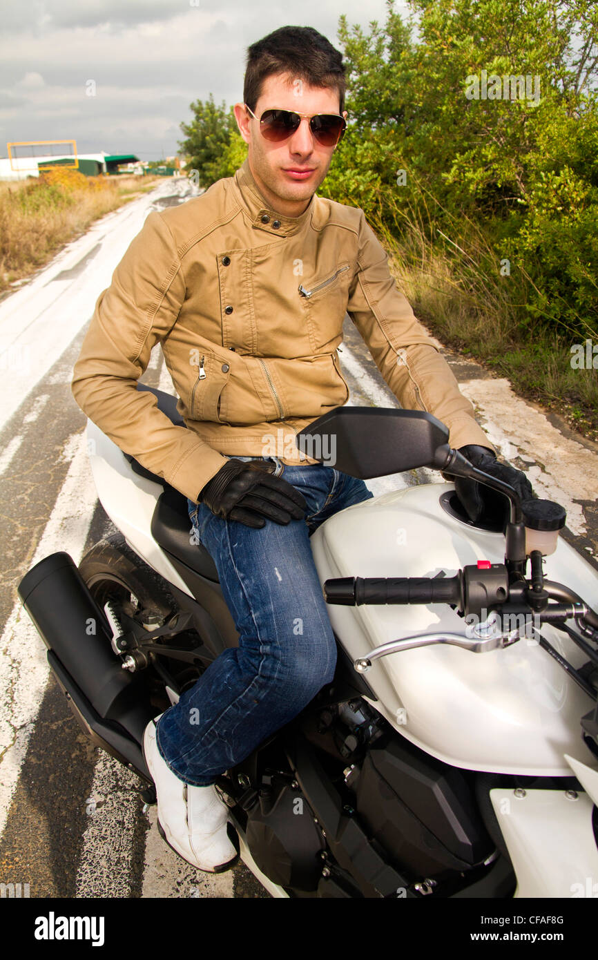 View of a man with a motorcycle on a asphalt road Stock Photo - Alamy
