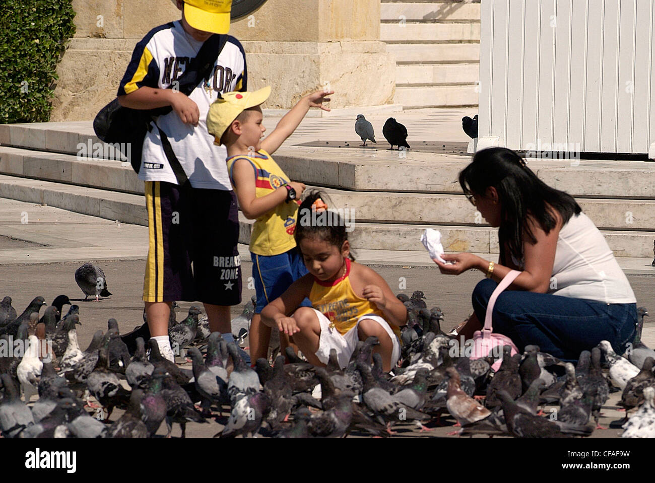Athens children feeding pigeons at the National War Memorial ...