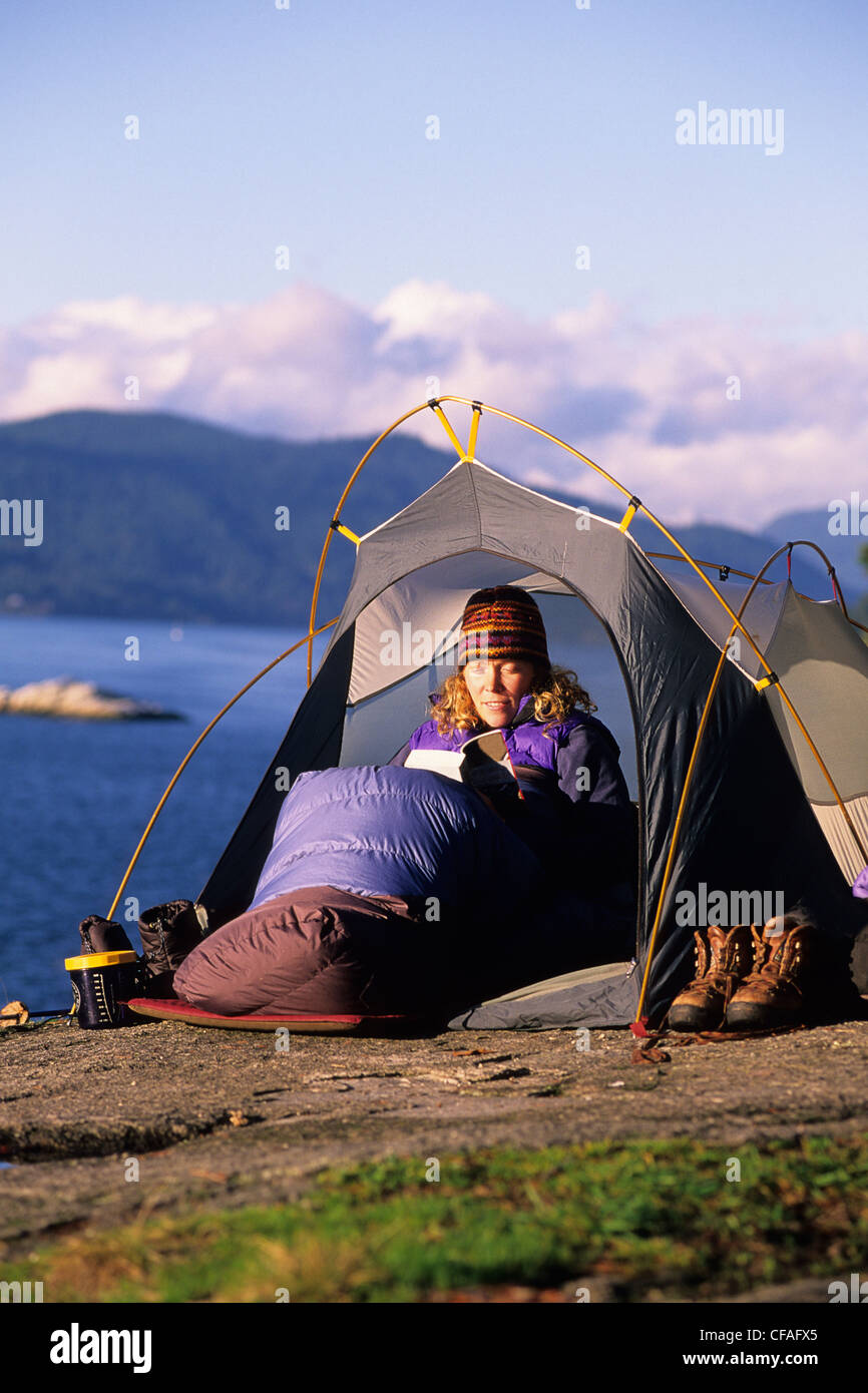 Woman reads a book in her tent, Lighthouse Park, West Vancouver ...