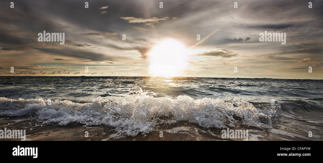 Sun shining over rocky waves Stock Photo - Alamy
