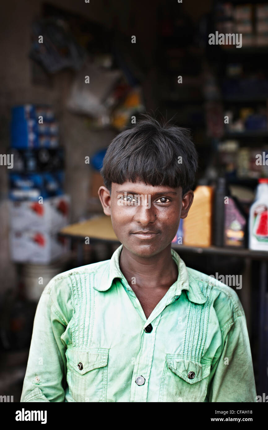 Smiling man sitting in front of shop Stock Photo - Alamy
