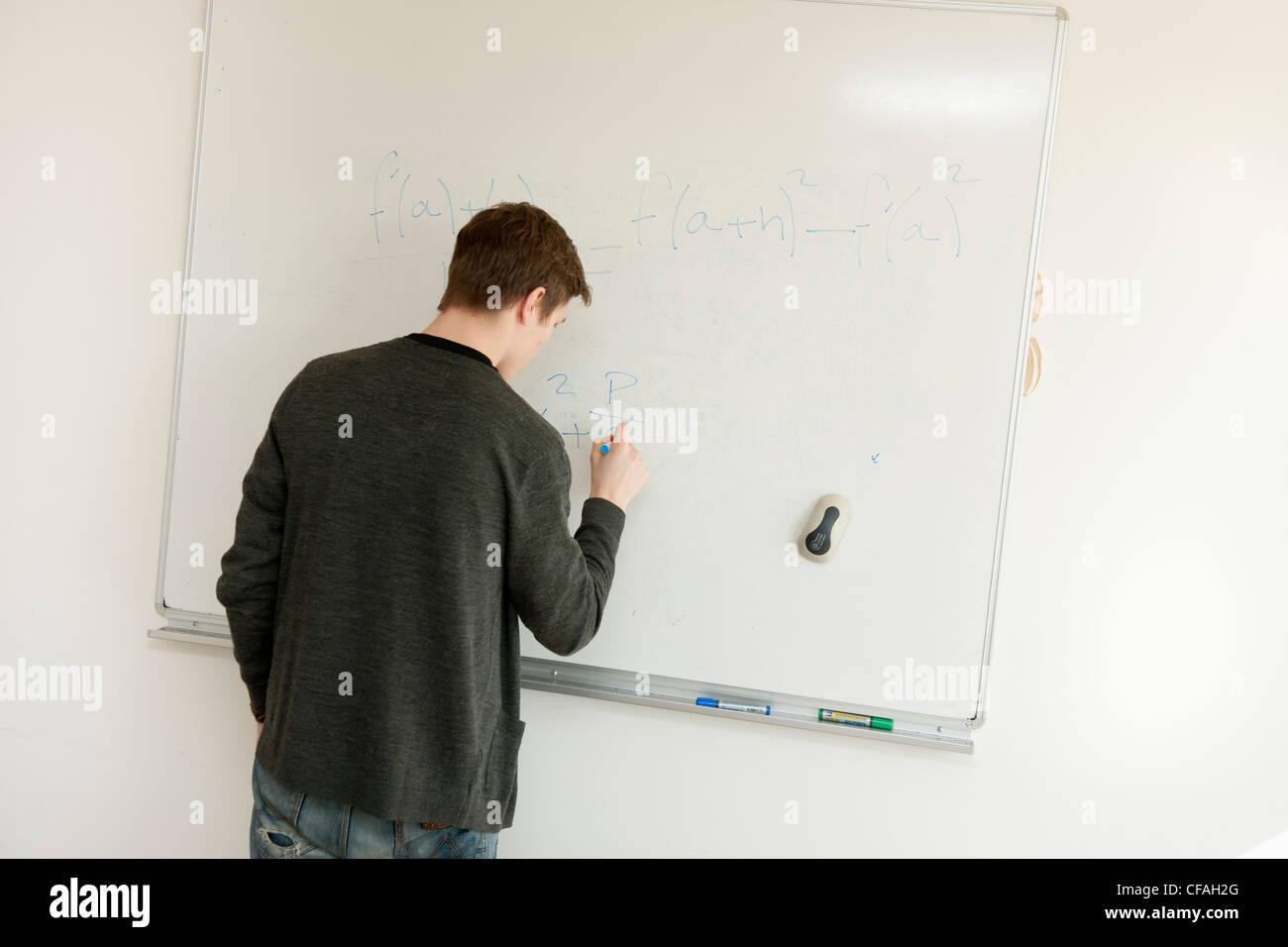 Young teacher writing on a whiteboard Stock Photo - Alamy