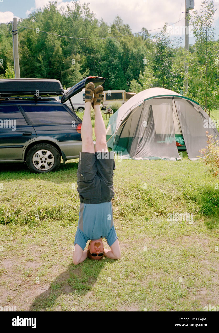 forty year old caucasian male practicing yoga during a camping ...