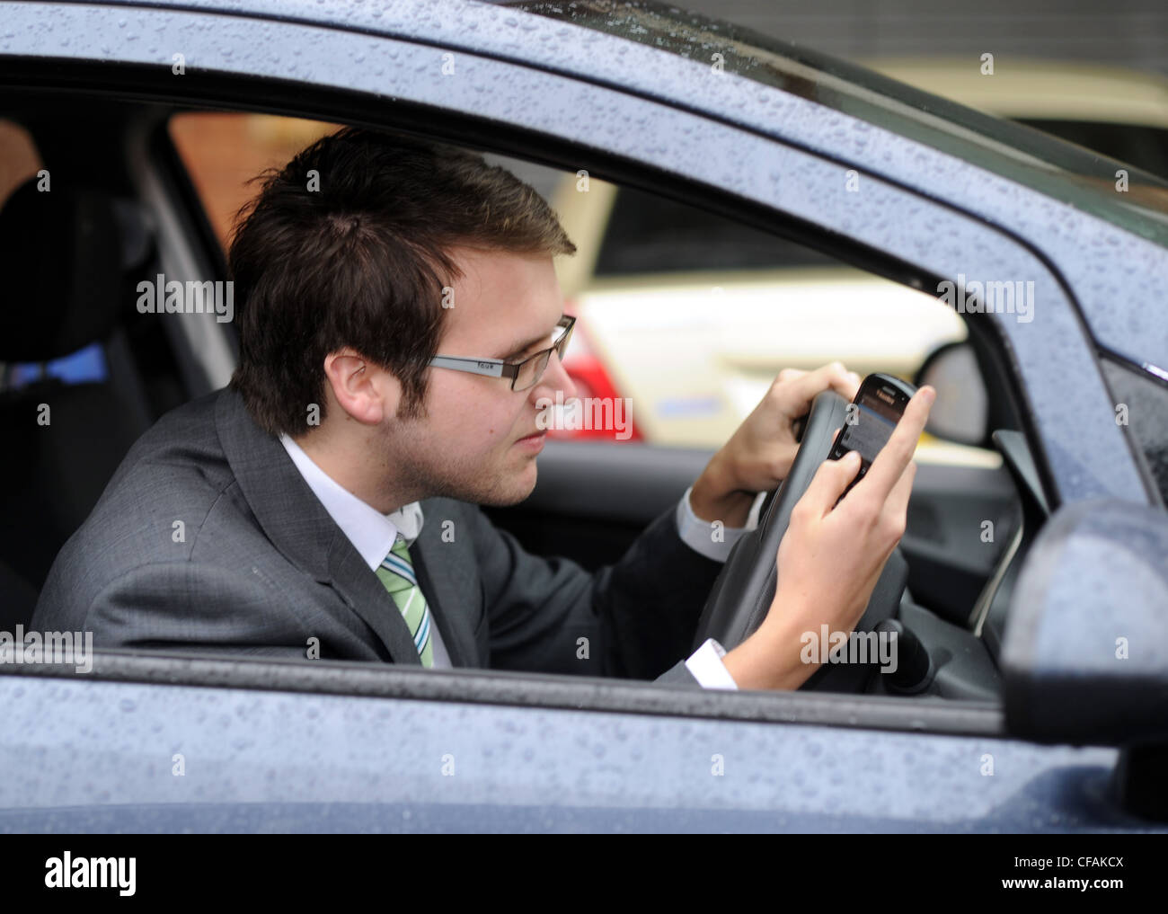 Posed by Model - A car driver using a Blackberry mobile telephone to ...