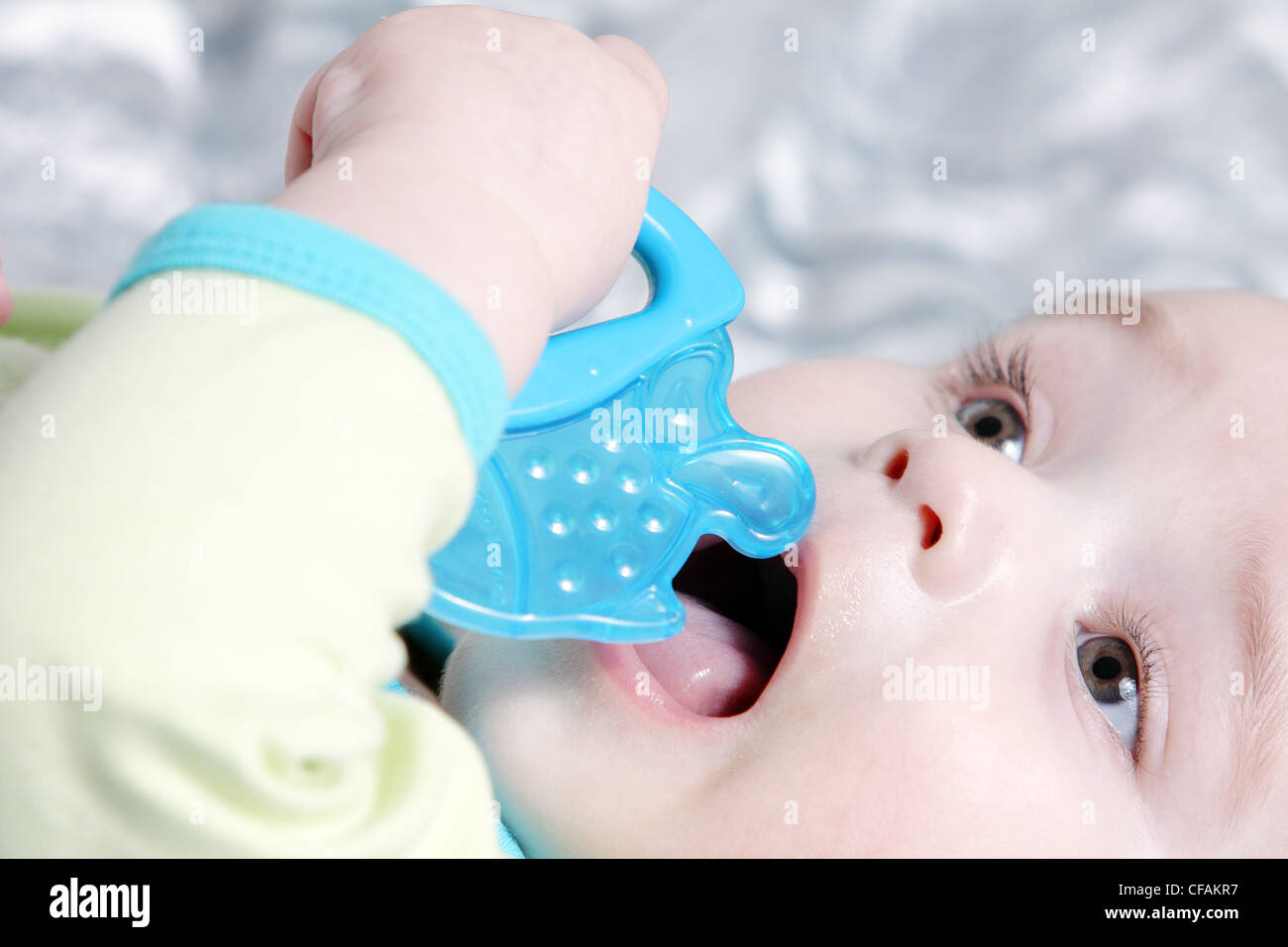 Cute baby with a blue fish teether Stock Photo - Alamy
