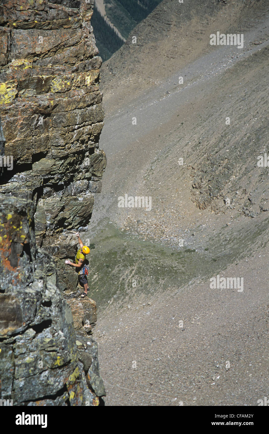 A young man climbing the Cardiac Arete on the Grand Sentinel, Alberta ...