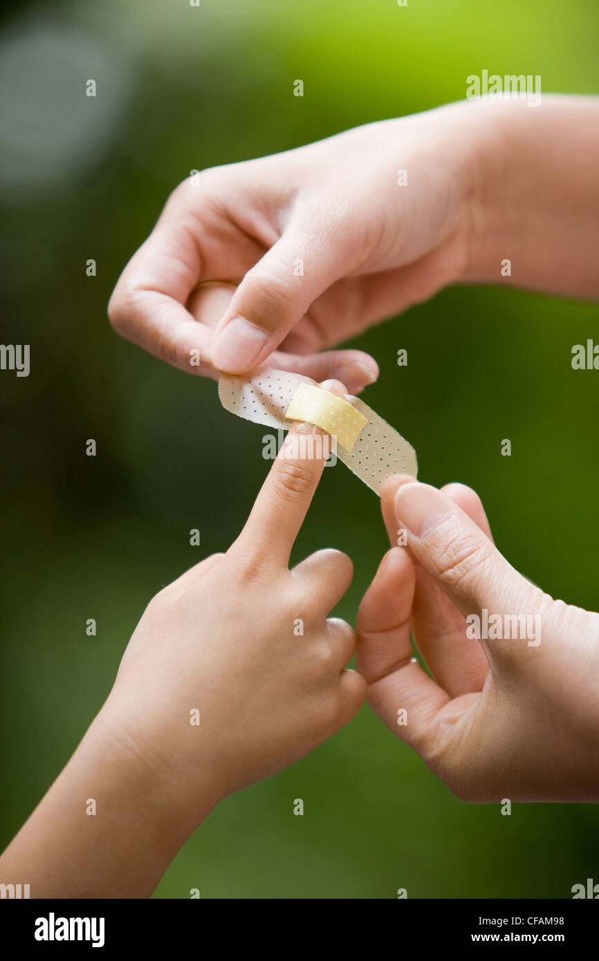 Sticking a patch on an injured finger Stock Photo - Alamy