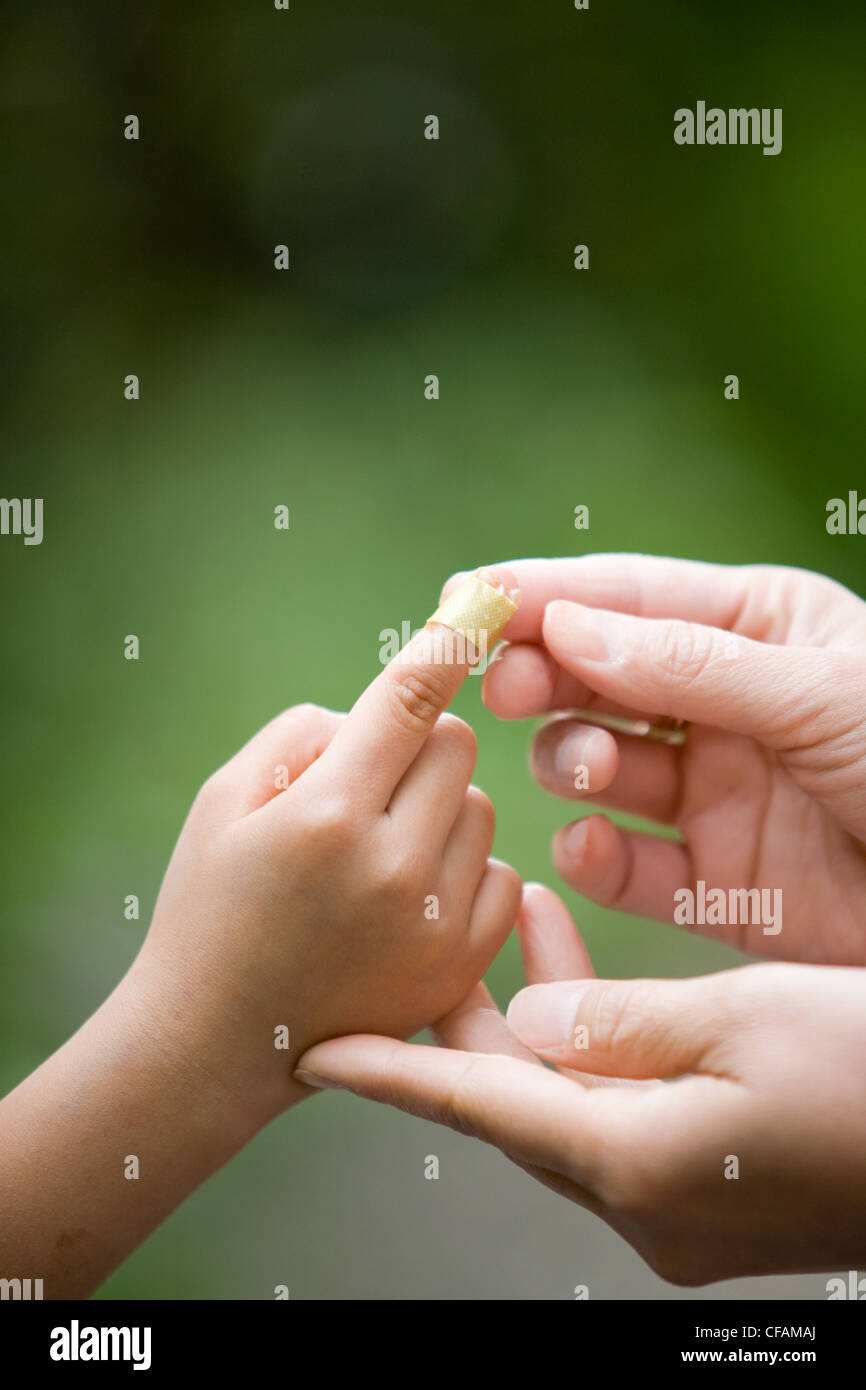 Sticking a patch on an injured finger Stock Photo - Alamy