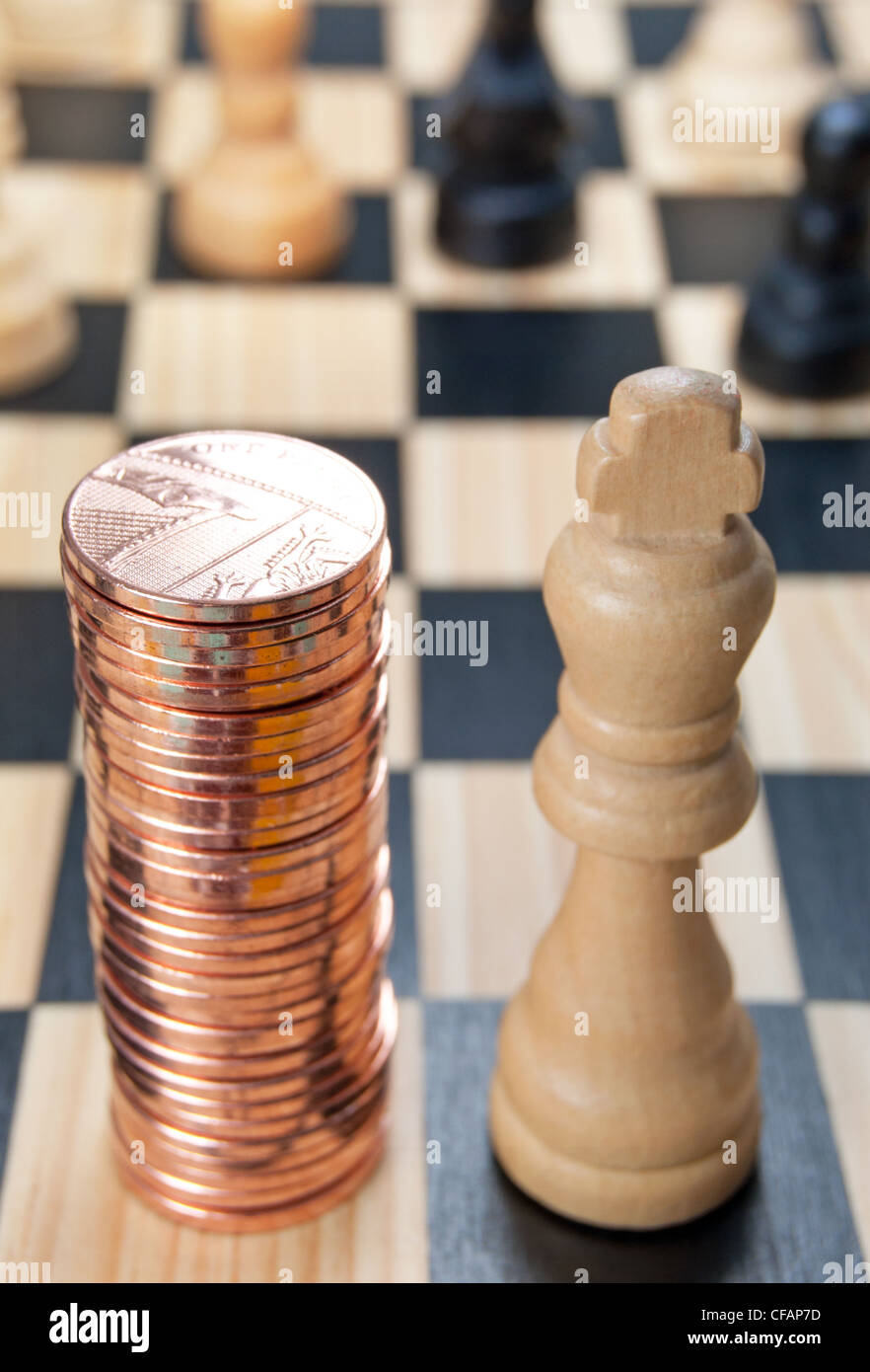 Stack of coins next to a chess king piece Stock Photo - Alamy