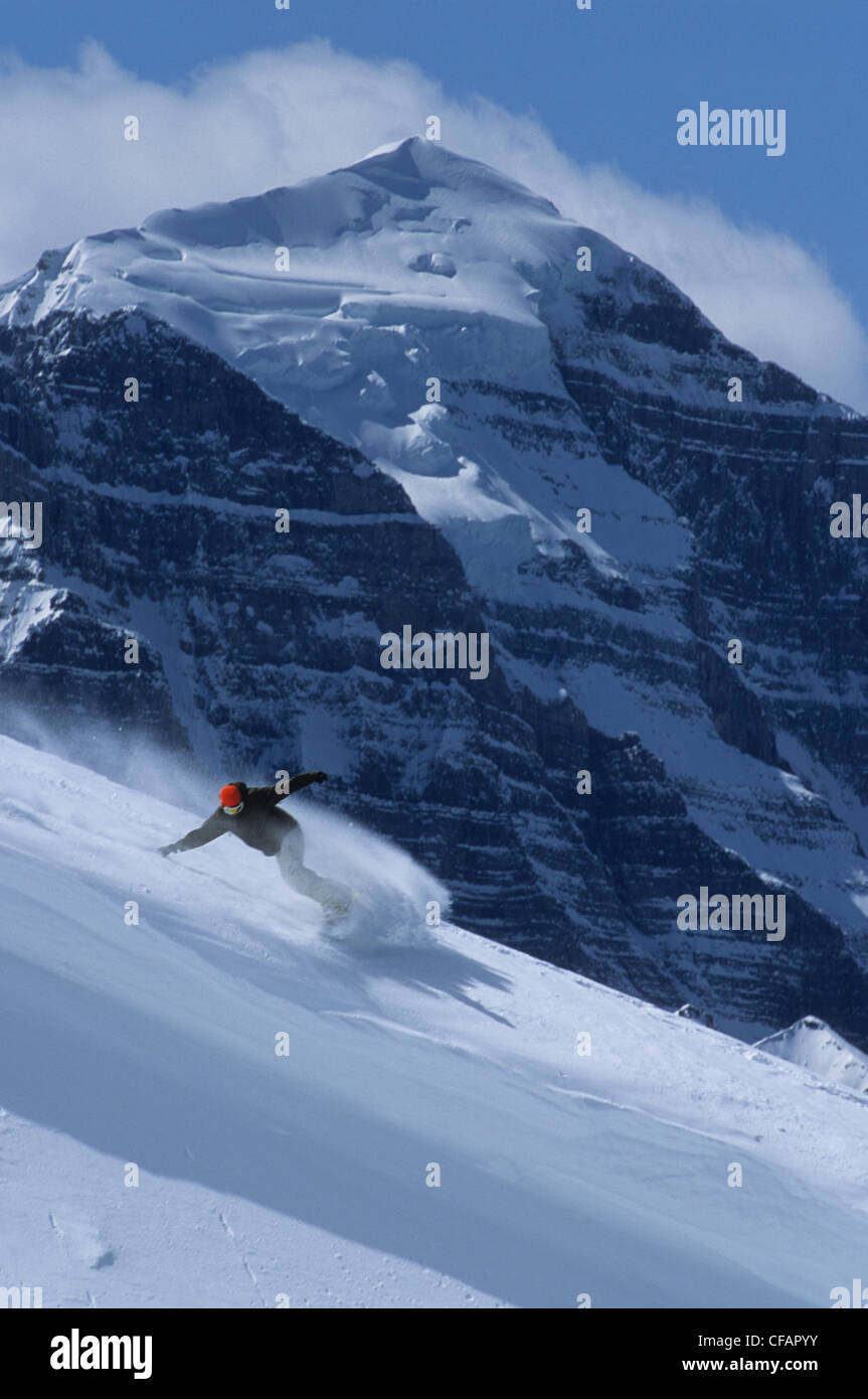 A snowboarder surfing the powder at Lake Louise, Temple Mountain, Banff ...