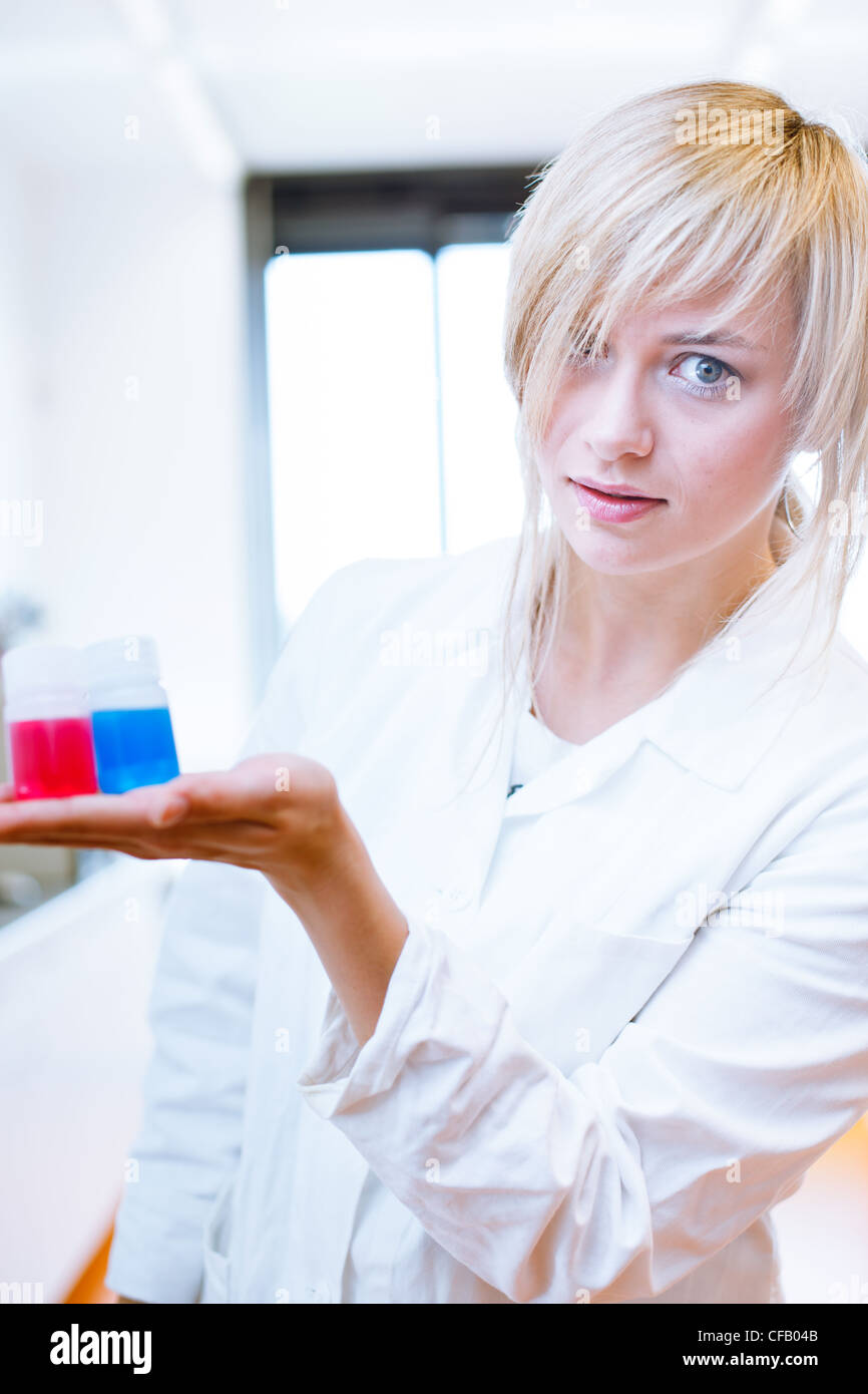 female researcher carrying out research experiments in a chemistry lab ...