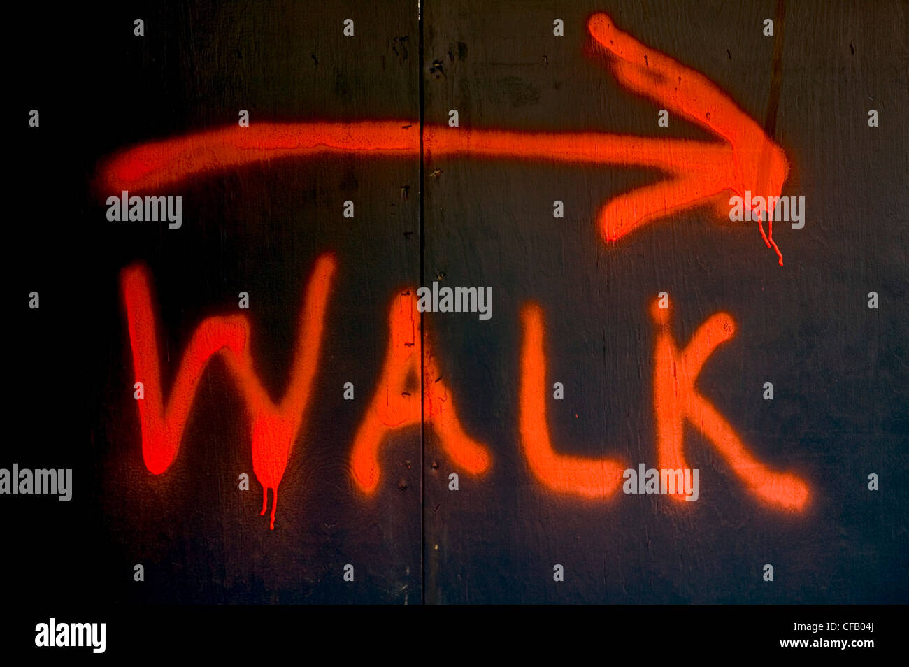 'Walk' sign and arrow painted in red Stock Photo - Alamy