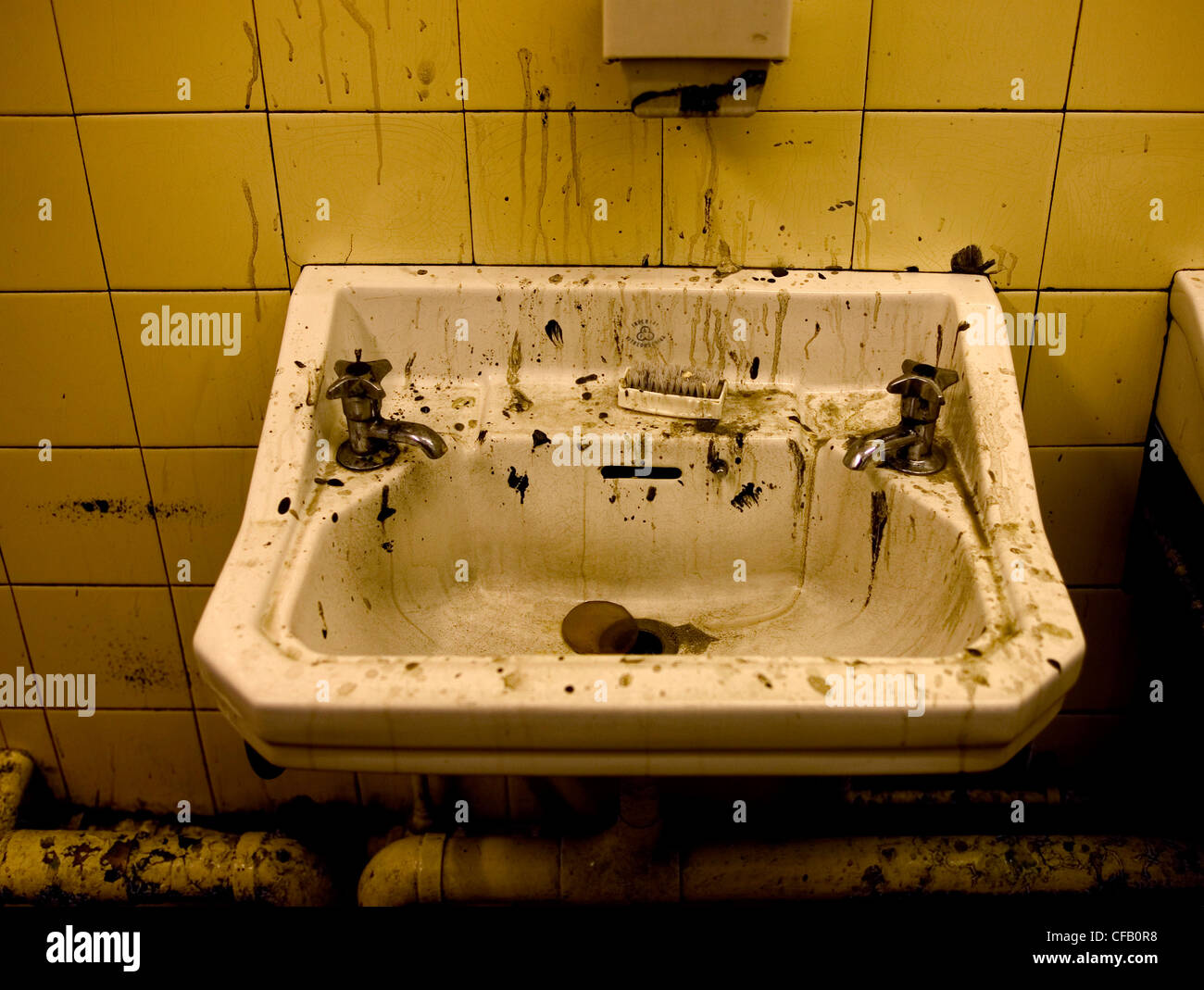 Basin with taps in public bathroom or toilet with mud and filth in the ...
