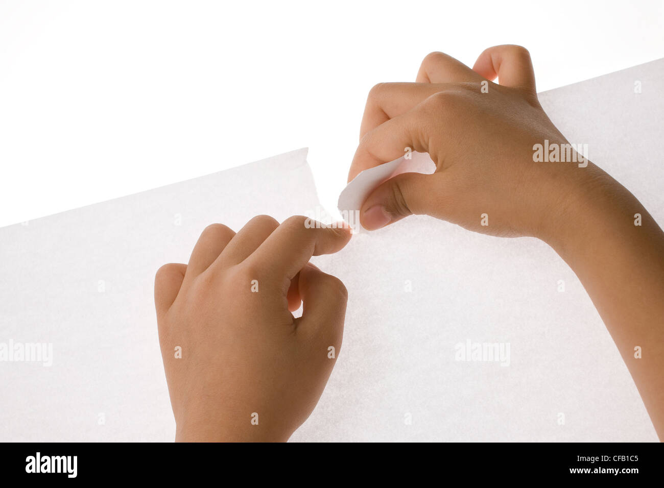 Hands tearing a precut sheet of blue paper isolated on white Stock ...