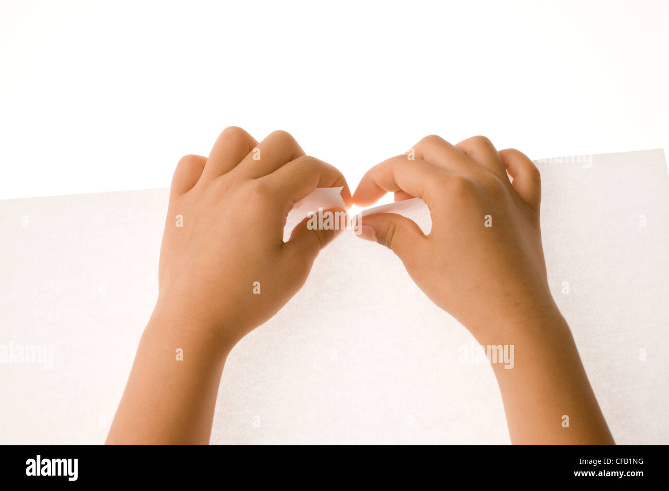 Hands tearing a precut sheet of blue paper isolated on white Stock ...