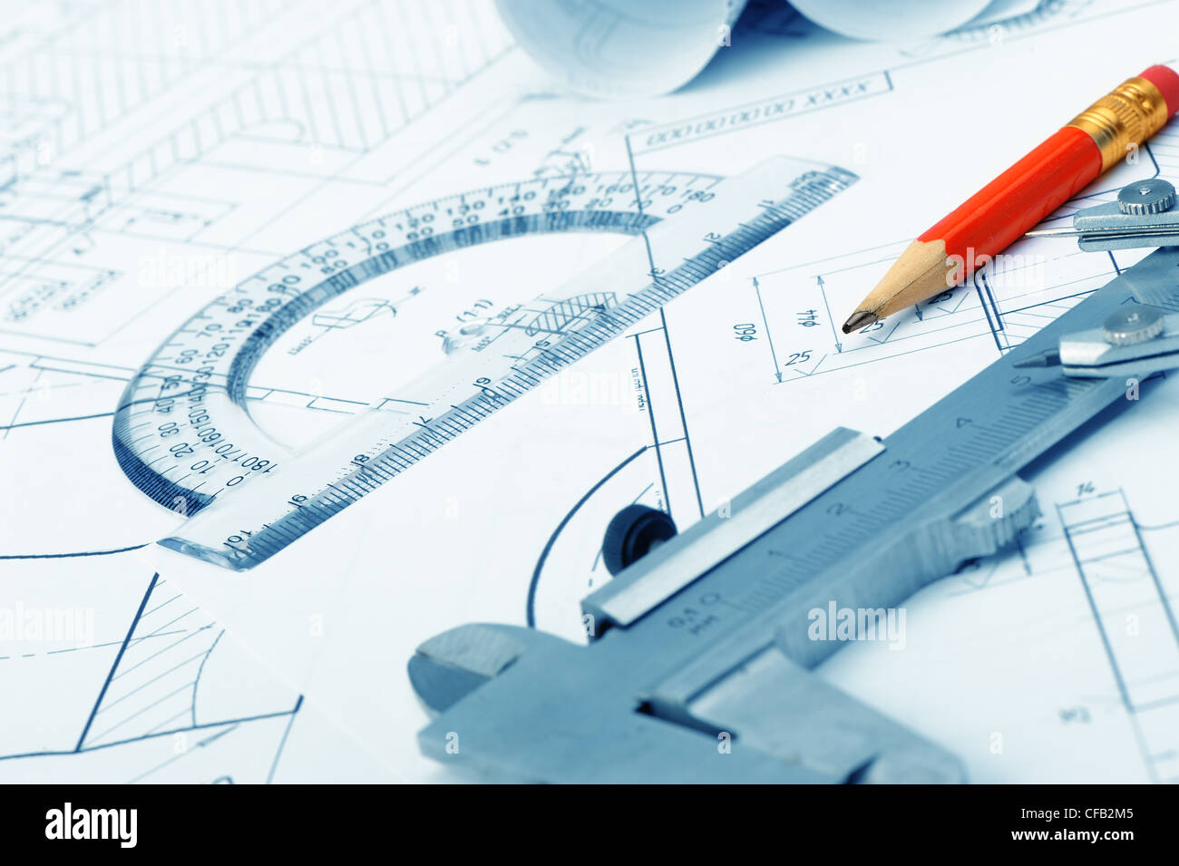 The plan industrial details, a protractor, caliper and a red pencil. A ...