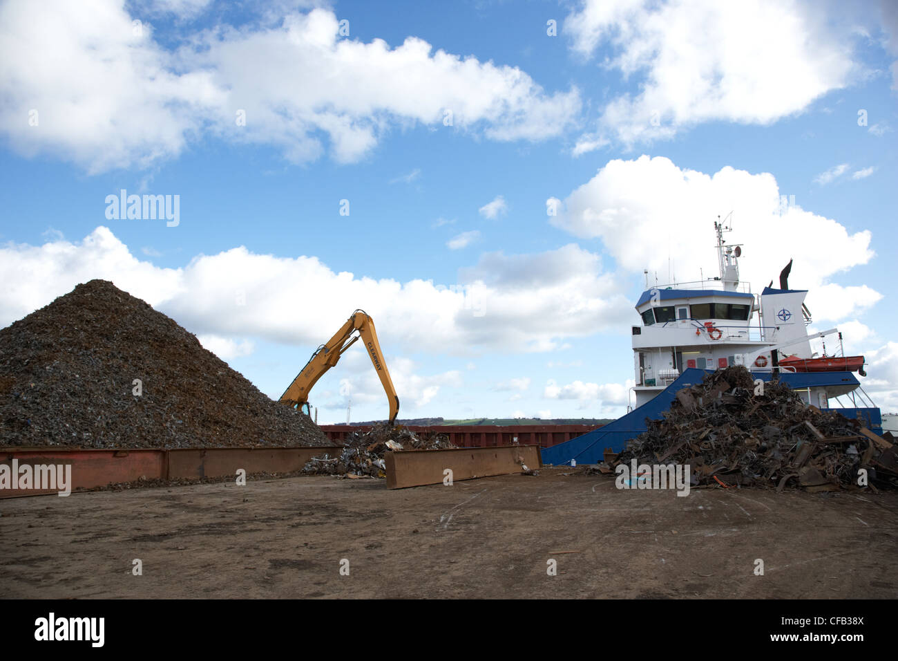 piles of recycled and shredded metals being loaded unto a ship at metal ...