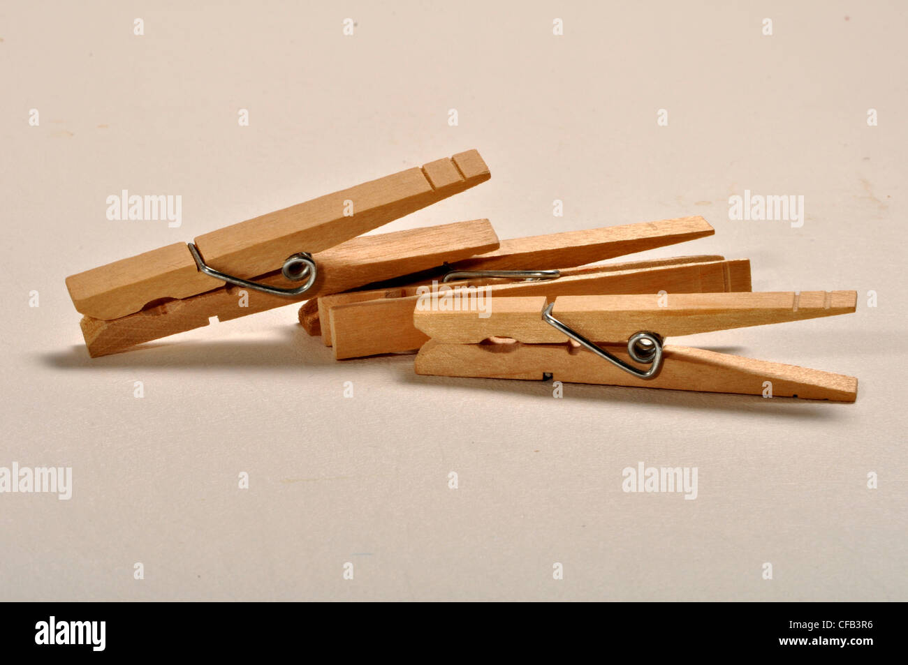 Three clothes pins are laying on a white background Stock Photo - Alamy