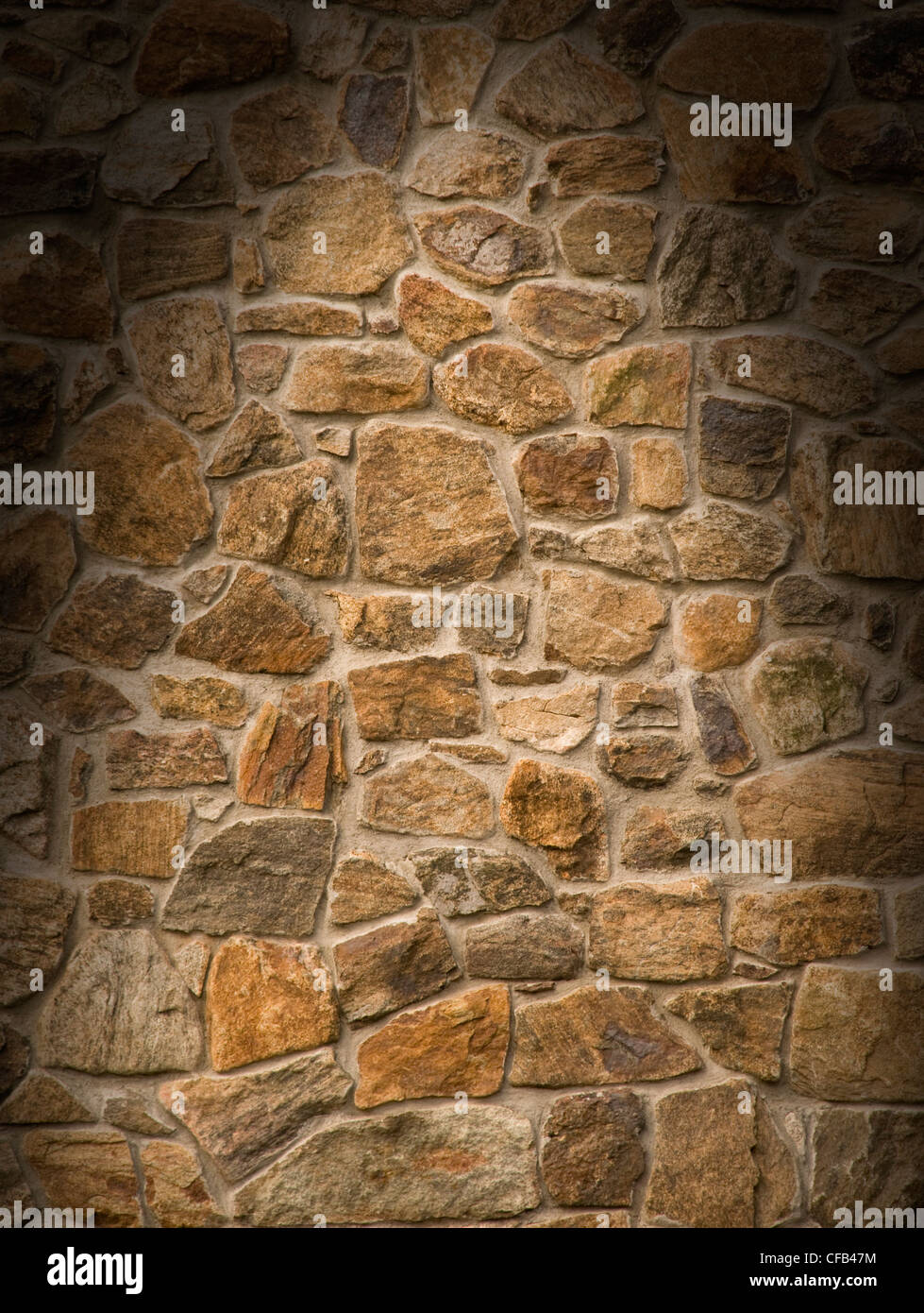 Brown masonry rock wall lit dramatically from overhead Stock Photo - Alamy