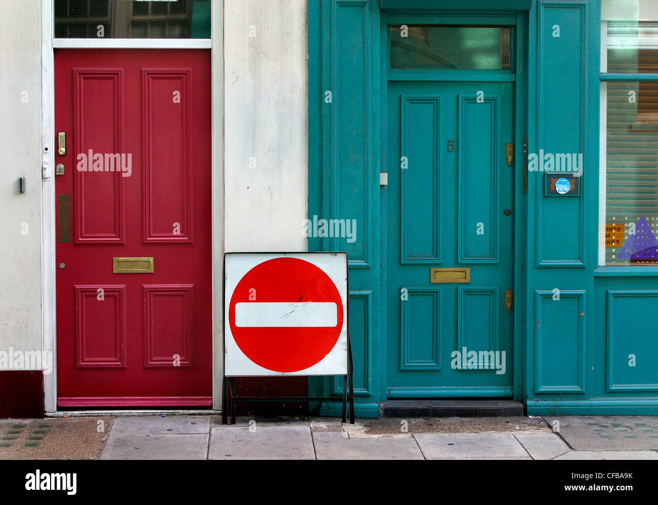 London street: no entry traffic sign on pavement between two houses ...
