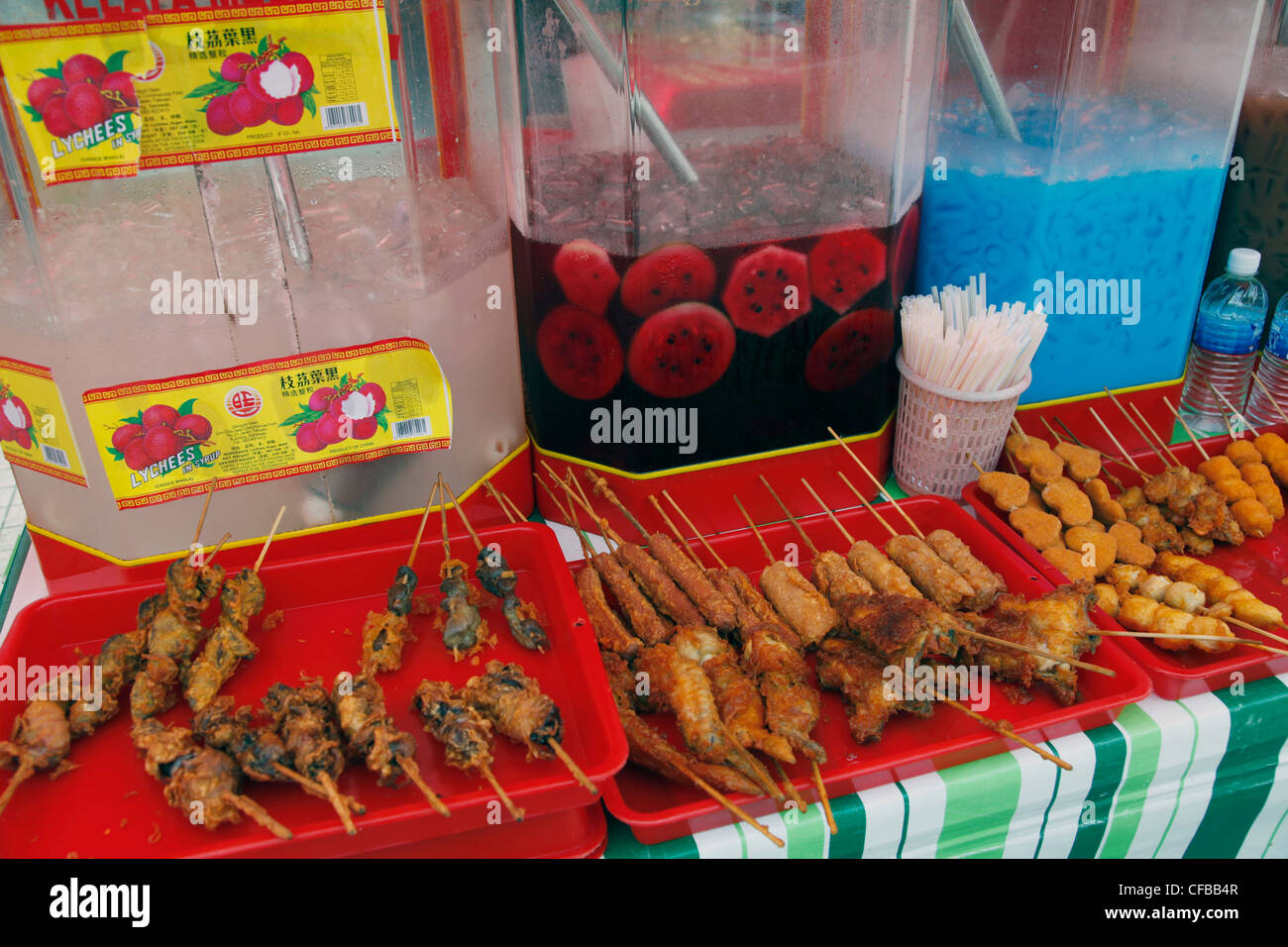 Snacks cooked in palm oil and fruit juices at a food stall in Kuala ...