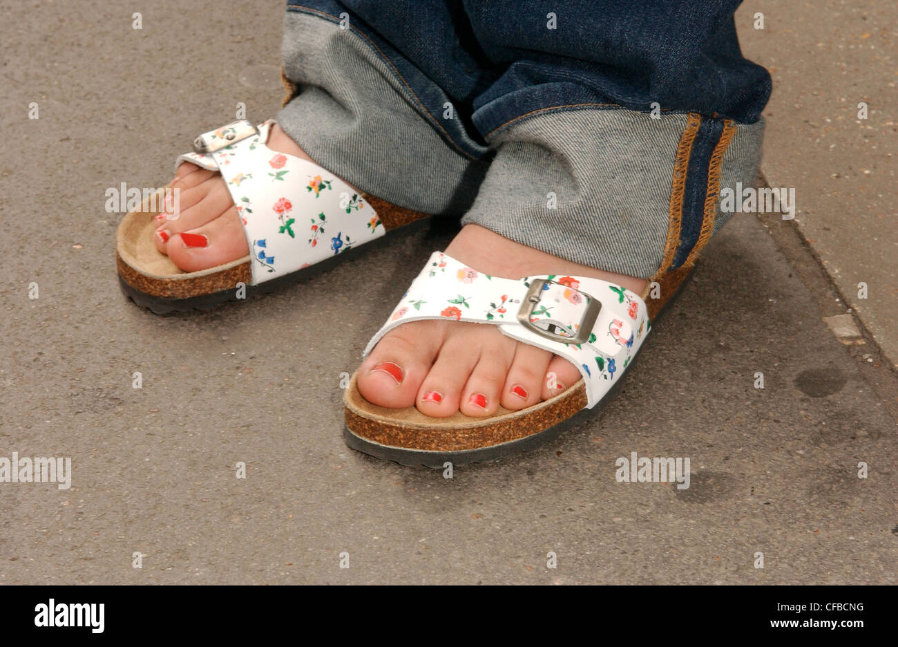 London Street Fashion Detail of cropped female feet wearing blue jeans ...