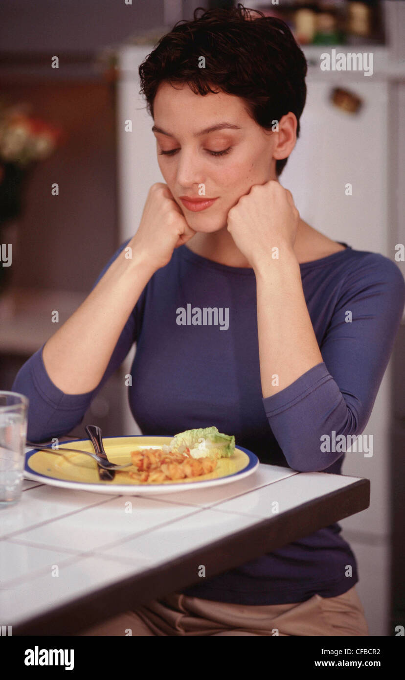 Female short brunette hair wearing blue top and beige trousers, sitting ...