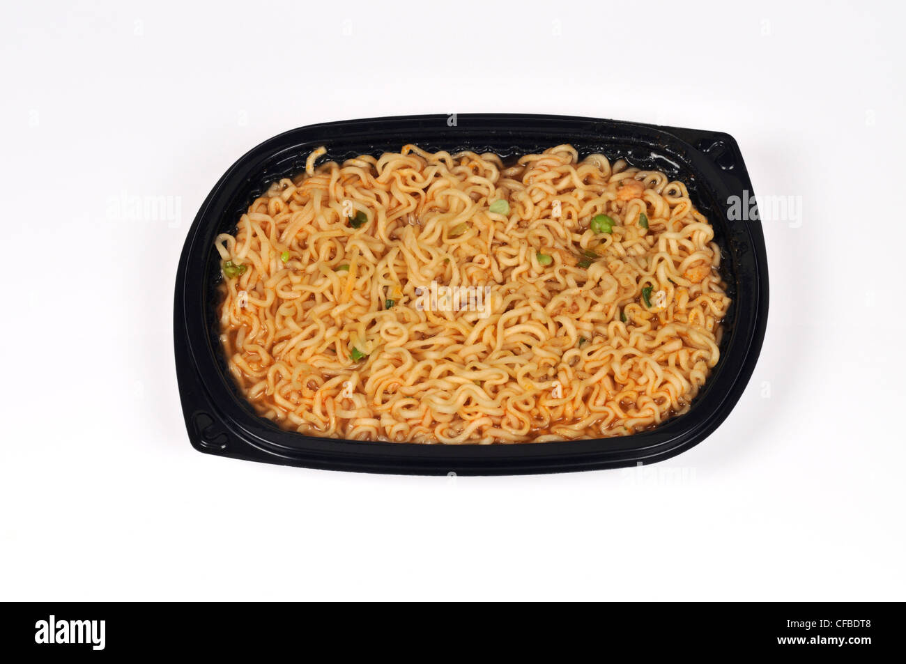 Oriental noodles with peas in black plastic tray on white background ...