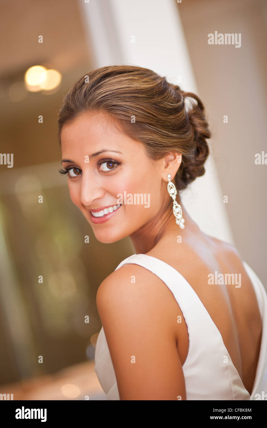 Beautiful bride looking over her shoulder and smiling Stock Photo - Alamy