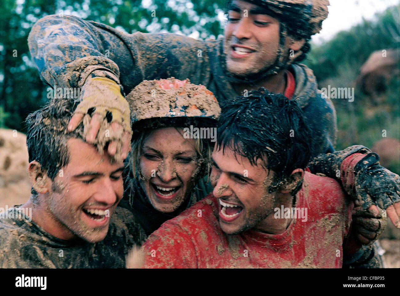 Group of males and female covered in mud Stock Photo - Alamy