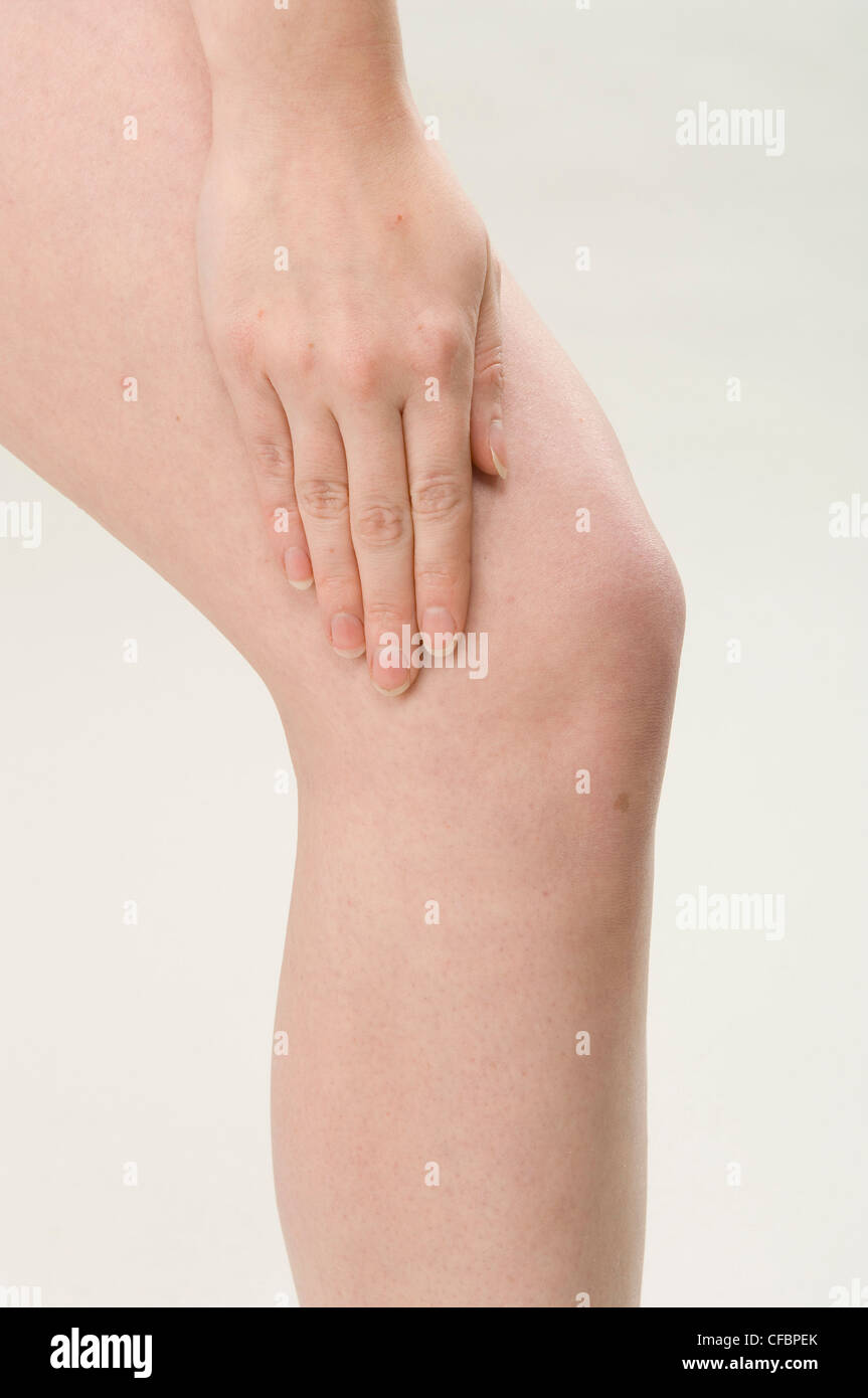 Female hand touching leg Stock Photo - Alamy
